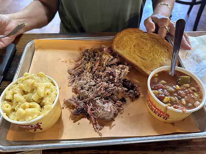 Pulled pork so tender it practically surrendered to the smoke, flanked by mac and cheese that's clearly living its best life.