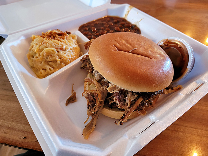 Behold the star attraction: a pulled pork sandwich that doesn't need Instagram filters to look this good, flanked by mac and cheese and baked beans.