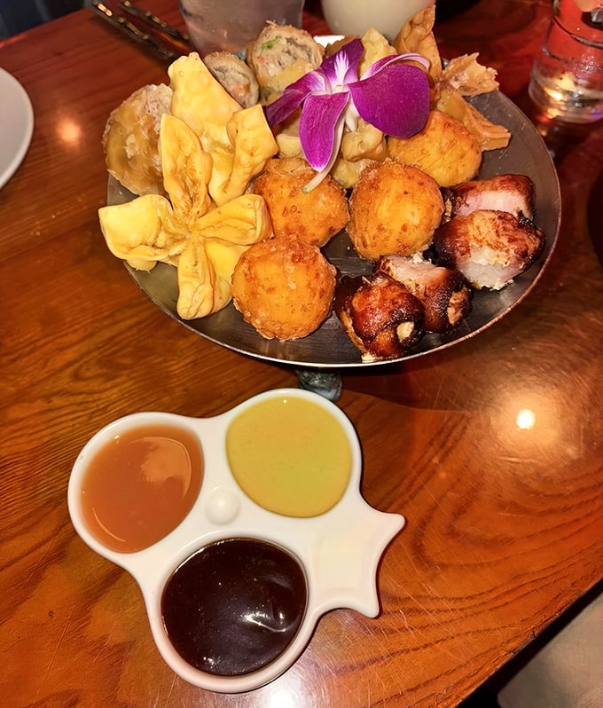 The pupu platter arrives like a tropical carnival for your taste buds, complete with a purple orchid that's saying "yes, this is fancy."