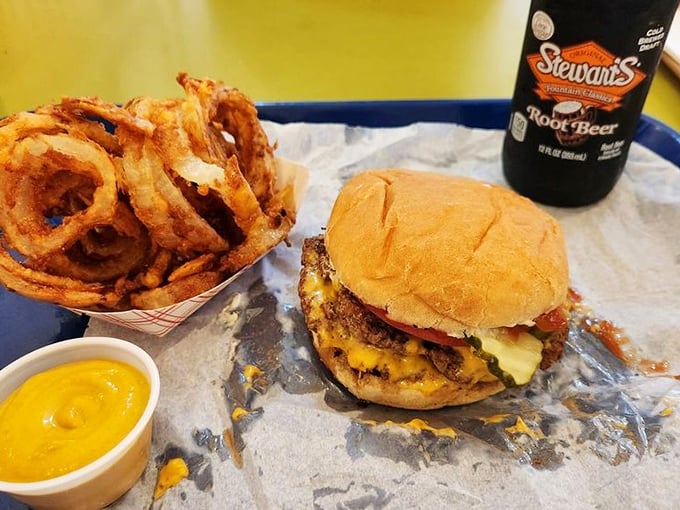 This isn't just a burger &ndash; it's a masterpiece of melted cheese cascading over multiple patties, with onion rings standing guard like crispy sentinels.