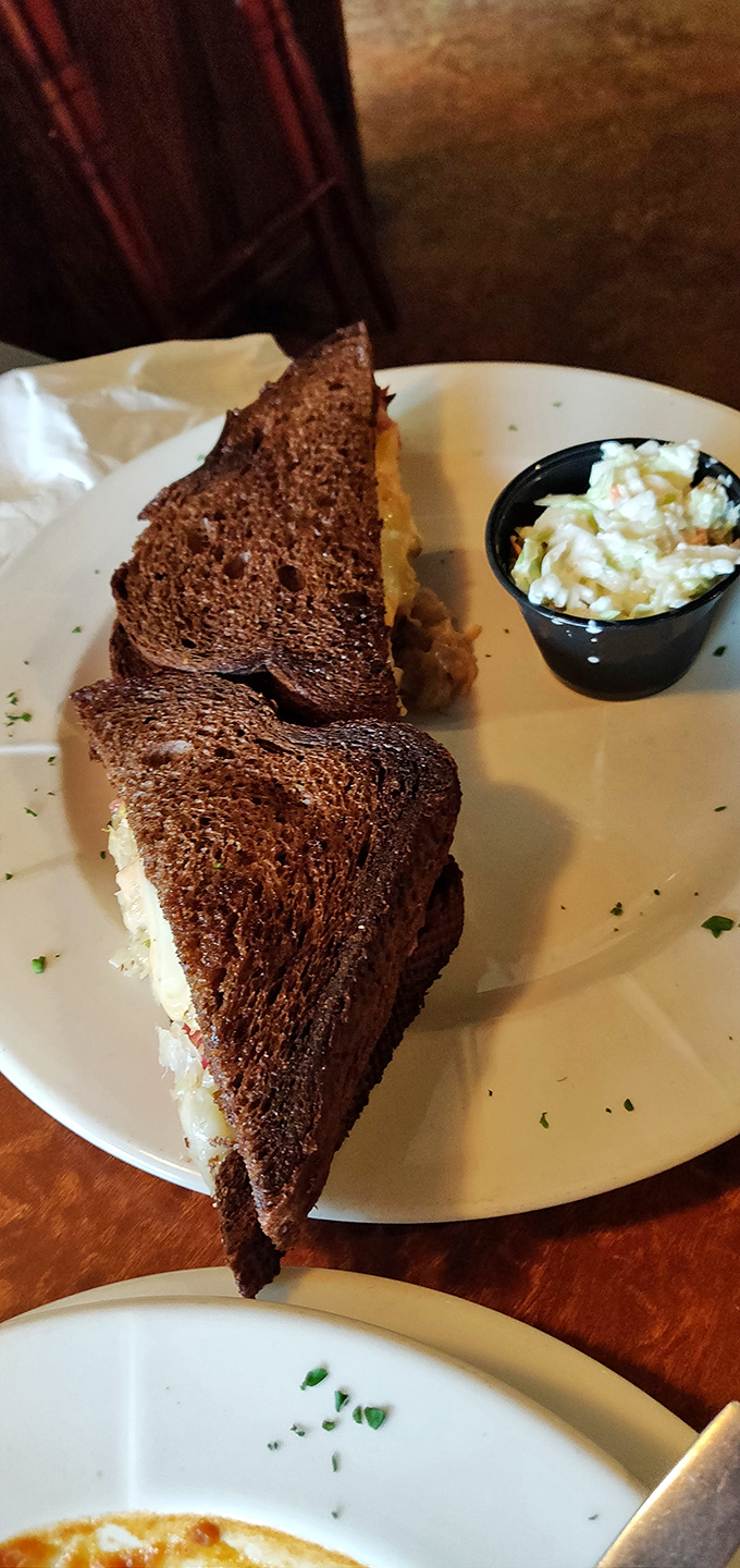 The legendary Reuben in all its glory &ndash; perfectly grilled rye bread embracing a mountain of corned beef, sauerkraut, and melted Swiss.