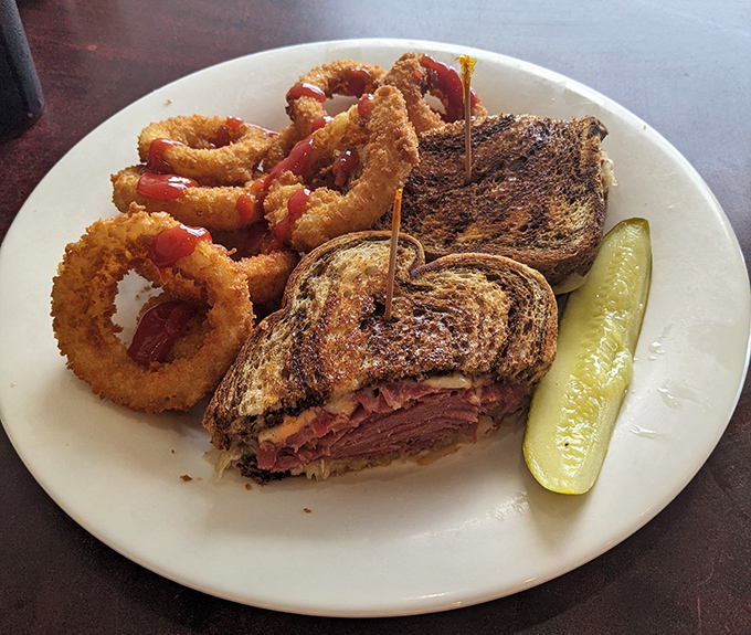 That perfect Reuben sandwich with golden onion rings isn't just lunch&mdash;it's therapy on a plate, complete with the mandatory pickle spear standing guard.