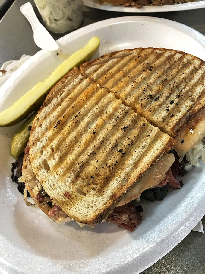 Behold the architectural marvel that is a proper grilled sandwich—perfect grill marks on rye holding a treasure of savory delights.