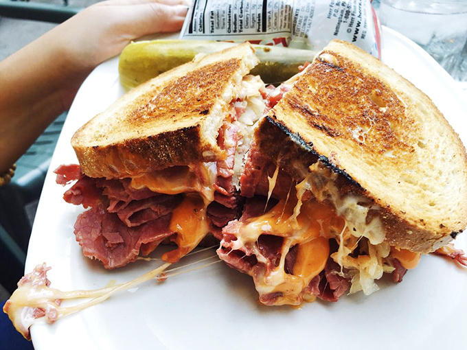 Behold the Reuben in its natural glory—where corned beef, sauerkraut, and Swiss cheese perform a harmonious dance that makes your mouth water involuntarily.
