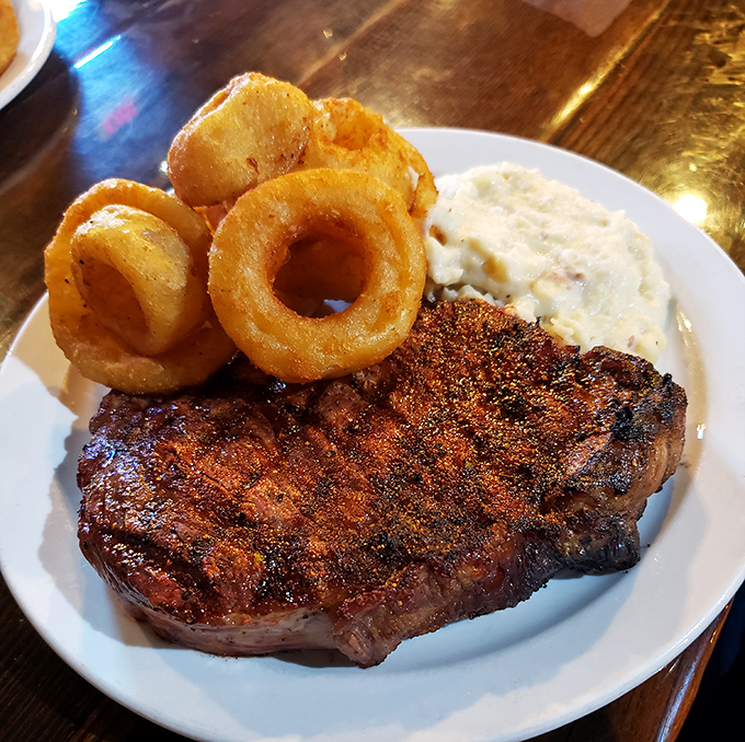 Behold the star of the show &ndash; a perfectly charred ribeye with those crispy onion rings and creamy mashed potatoes that'll haunt your dreams.
