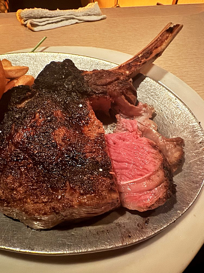 Behold the ribeye in its natural habitat—perfectly charred exterior, blushing interior, and a bone that deserves its own thank-you note.