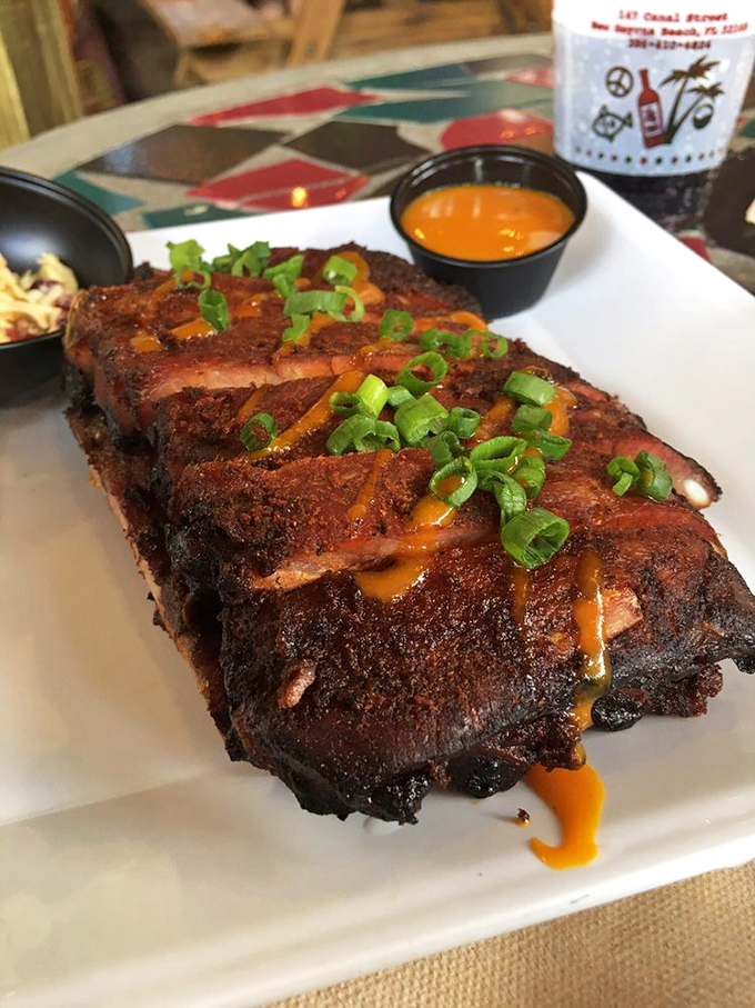 Behold the star of the show: ribs with that perfect bark, kissed by smoke and drizzled with their famous "Gold" sauce. The green onion garnish isn't just pretty&mdash;it's necessary balance.