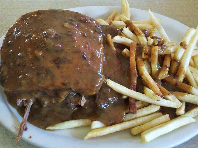 Gravy isn't just a condiment here—it's practically a food group. This open-faced roast beef sandwich swimming in rich brown gravy makes a compelling case for wearing a bib.