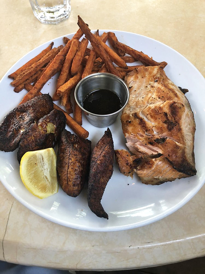Not just salmon&mdash;a culinary statement with sweet potato fries and plantains. This plate doesn't need a filter; it's already Instagram-ready.