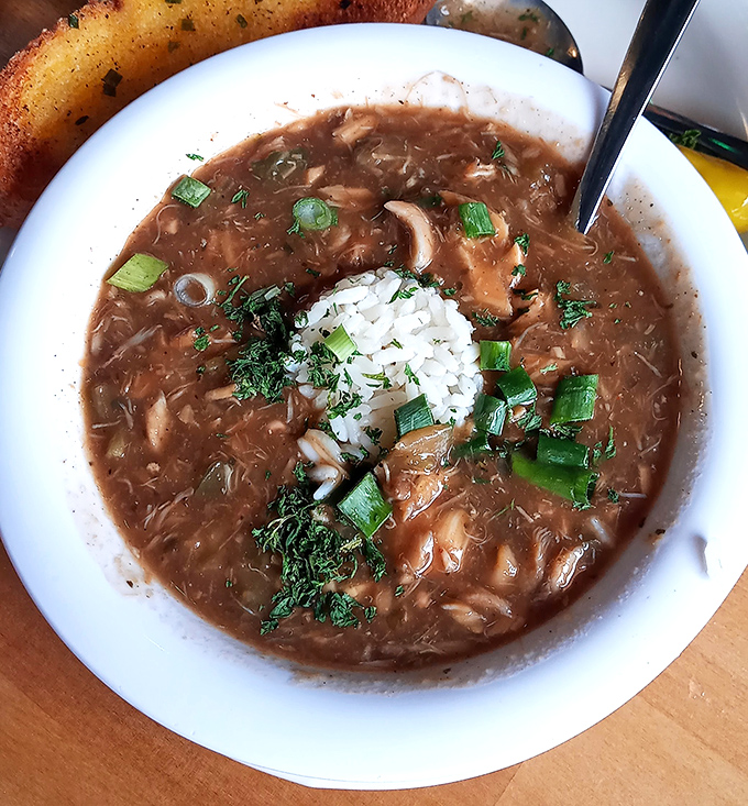 This isn't just gumbo; it's a dark, mysterious bayou in a bowl, complete with rice island rising from the flavorful depths.