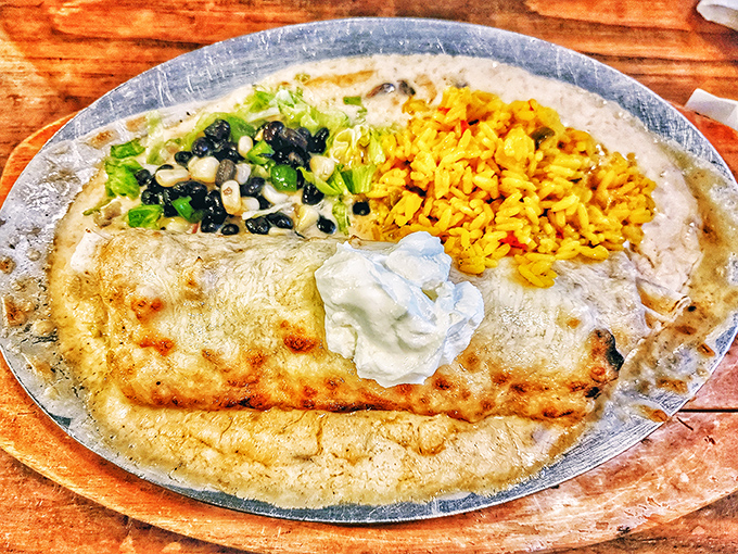 Behold the seafood burrito in all its glory! Like a beach vacation wrapped in a tortilla, complete with yellow rice and a dollop of cool sour cream.