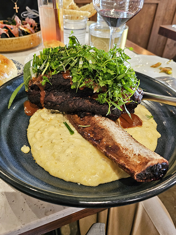This short rib isn't just falling off the bone&mdash;it's practically filing for independence. Nestled on creamy polenta with fresh herbs, it's comfort food with a PhD.