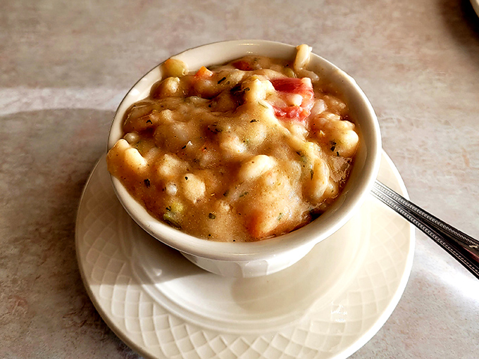 The legendary shrimp bisque arrives like a creamy coral dream, studded with tender seafood morsels that make you question all other soups.