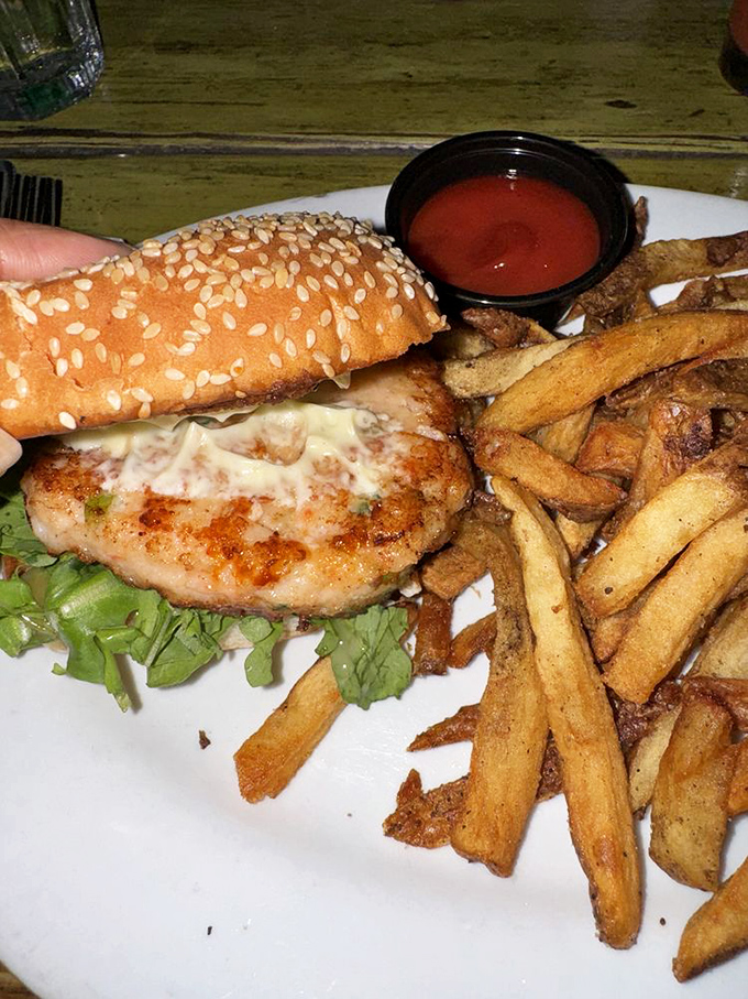 This isn't just any shrimp burger&mdash;it's a masterpiece of seafood engineering, with crispy fries and tangy sauce completing the holy trinity of diner perfection.