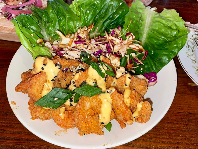 These aren't your average lettuce wraps &ndash; crispy shrimp nestled in butter lettuce with Asian slaw creates a perfect harmony of crunch, spice, and freshness.