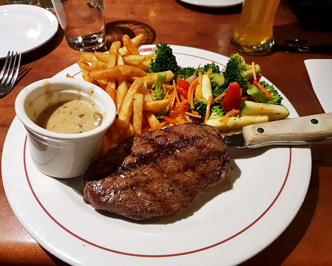 This perfectly seared sirloin arrives like a work of art&mdash;accompanied by golden fries, vibrant vegetables, and a sauce that deserves its own fan club.