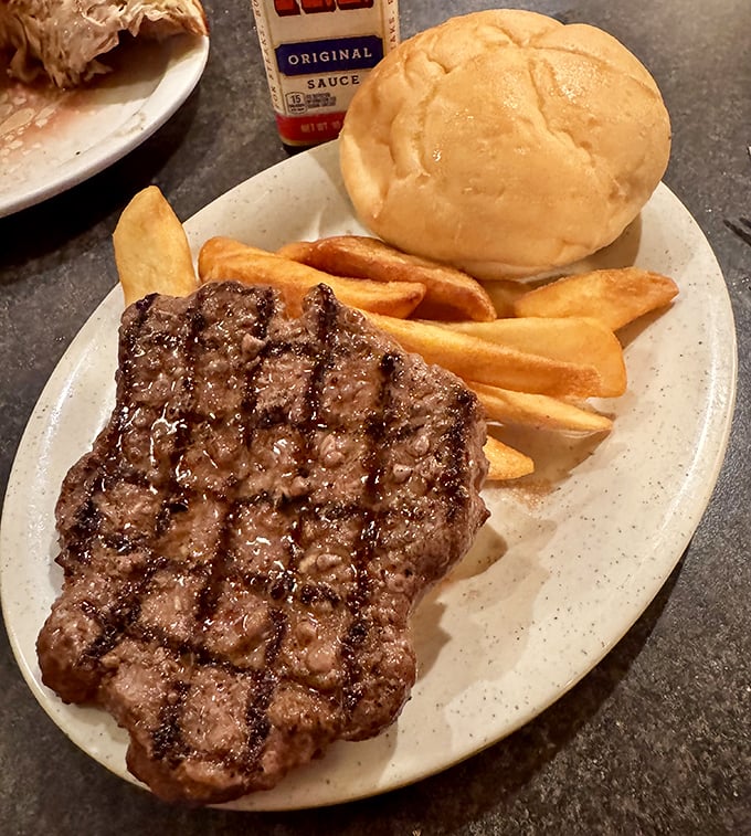 Behold the star of the show: a perfectly grilled sirloin with those coveted crosshatch marks, accompanied by golden fries and a bun that's ready for its supporting role.