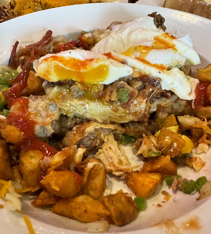 Behold the legendary skillet in all its glory—where crispy potatoes, melted cheese, and perfectly runny eggs unite in breakfast harmony.