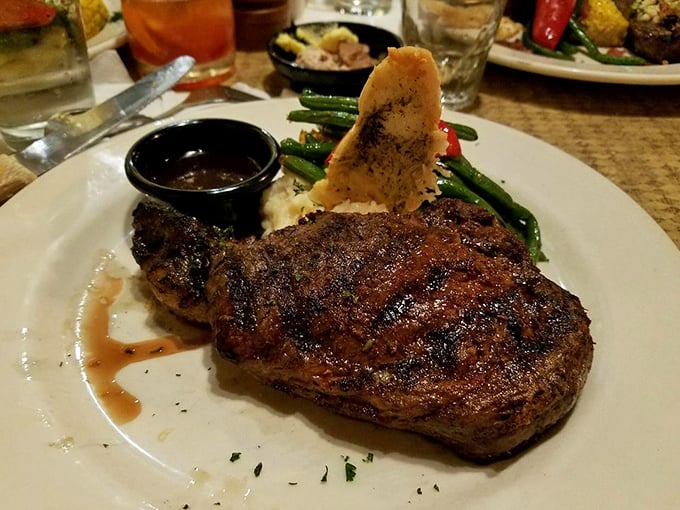 This perfectly seared steak isn't just dinner&mdash;it's a religious experience. The char marks are practically artwork, with sides playing worthy supporting roles.