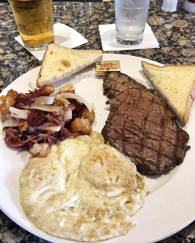 Behold the star attraction: perfectly seared prime rib alongside sunny eggs and home fries. Breakfast doesn't get more magnificent than this protein paradise.