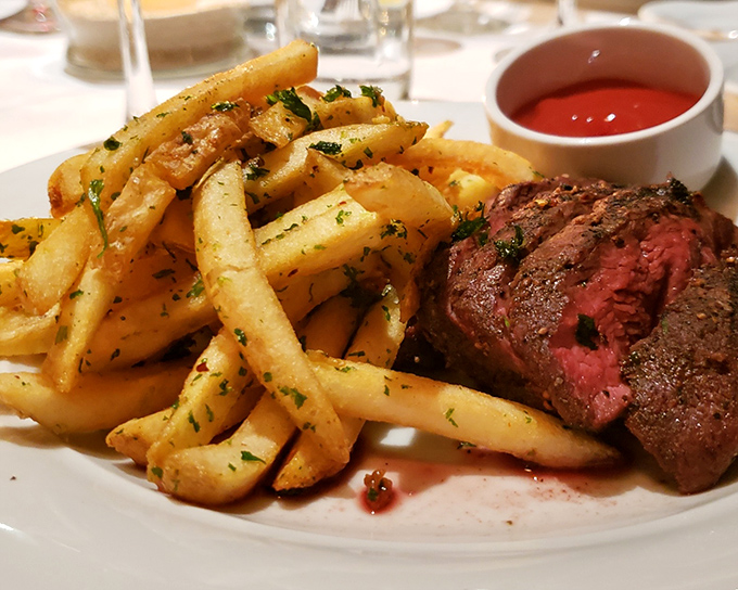 Behold the star attraction: perfectly seared steak alongside herb-flecked fries that somehow remain crisp until the last bite. A masterclass in simplicity.