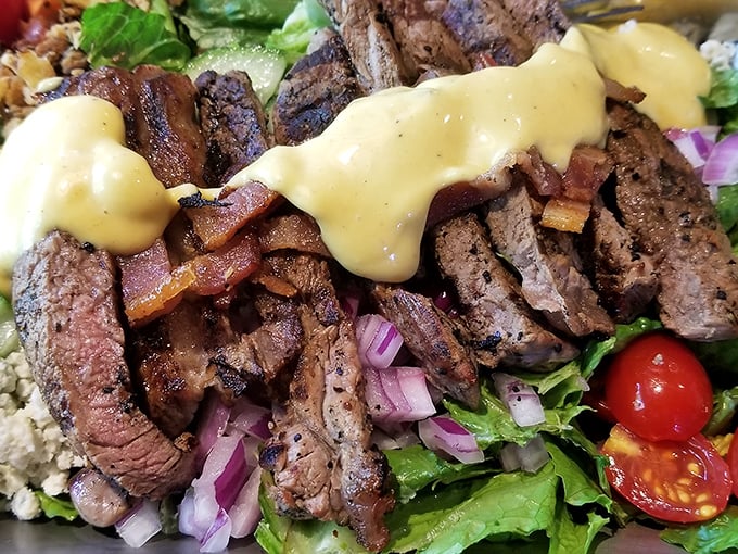 Behold the infamous steak salad! Perfectly seared beef lounging atop fresh greens like it owns the place, with a sauce that should require a license to serve.