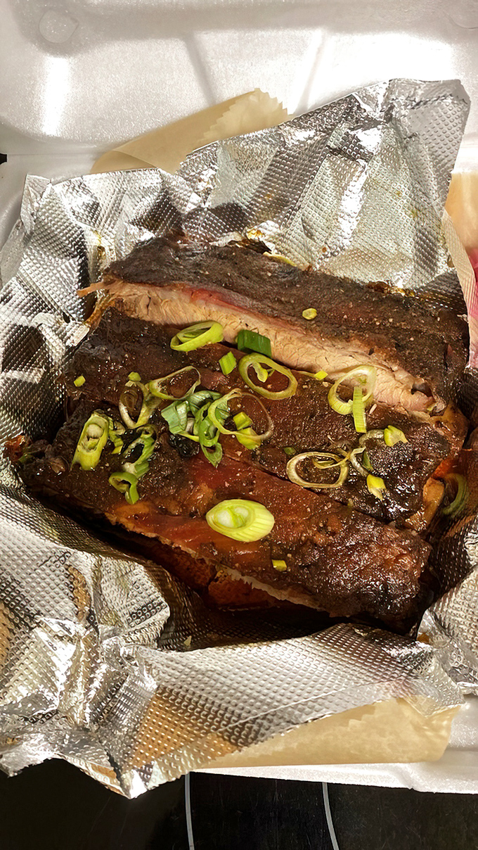 Behold the star of the show: ribs so perfectly lacquered they practically wink at you. That smoke ring is nature's way of saying "good things come to those who wait." 