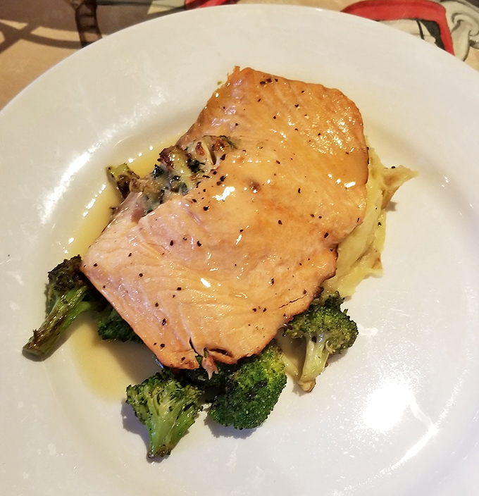Perfectly cooked salmon rests atop vibrant broccoli like a culinary sunset, glistening with a sauce that demands to be savored.