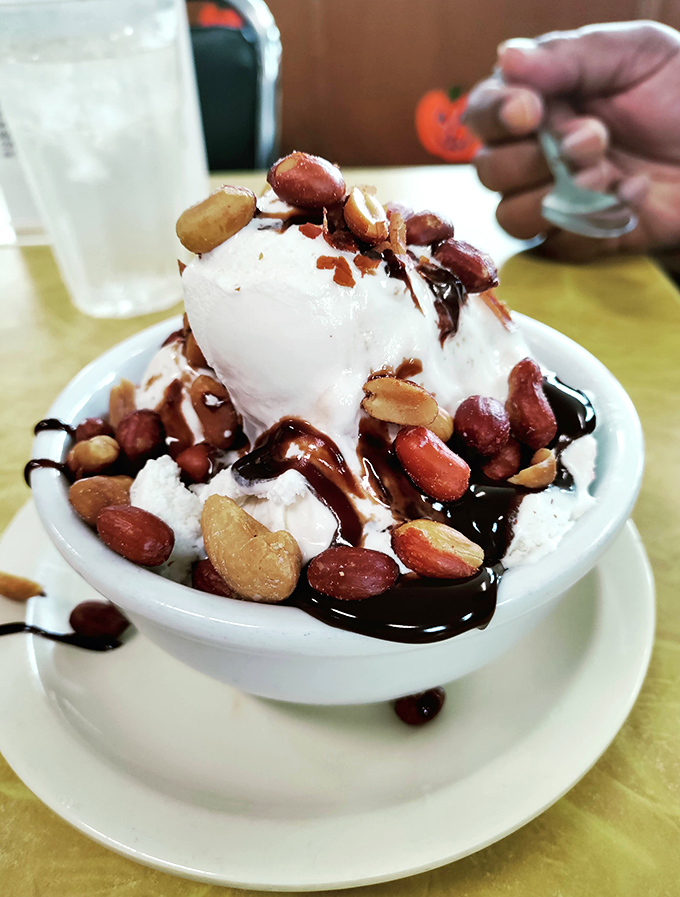 Ice cream architecture at its finest. Vanilla scoops crowned with freshly roasted nuts and chocolate sauce&mdash;proof that perfection exists in a bowl.