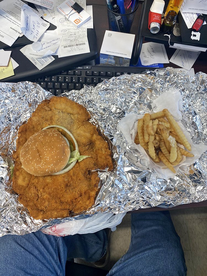 Behold the tenderloin in its natural habitat&mdash;sprawled majestically across aluminum foil like it's sunbathing on a metallic beach, making that regular-sized bun look like a tiny hat.