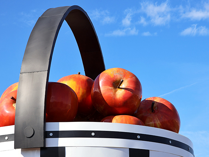 Up close with the basket's crown jewels! These giant apples perch precariously atop their woven throne, stems standing at attention like tiny flagpoles.