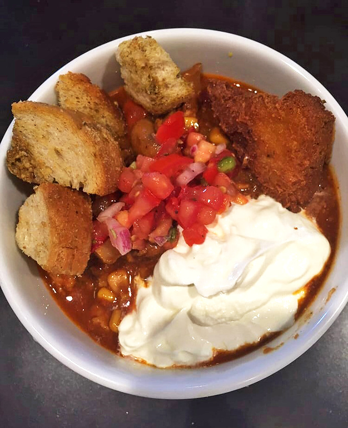 A bowl of hearty turkey chili, topped with fresh pico de gallo and sour cream&mdash;comfort food that hugs your insides like a warm Pennsylvania morning.