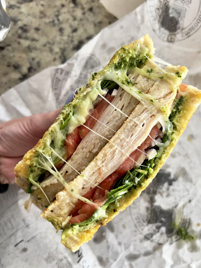 Cheese stretches like a suspension bridge between layers of turkey and veggies, all nestled between bread that makes store-bought look like a sad distant relative.