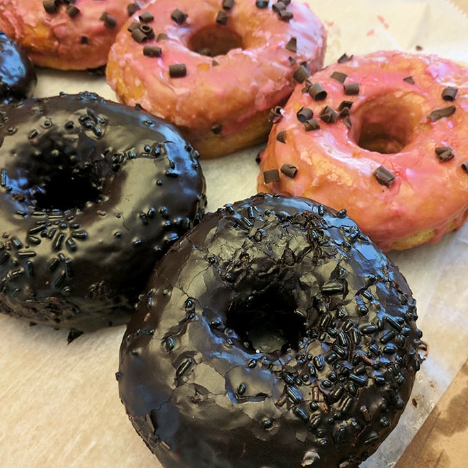 Chocolate glazed beauties with sprinkles alongside pink-frosted delights. These aren't just donuts&mdash;they're edible art with attitude.