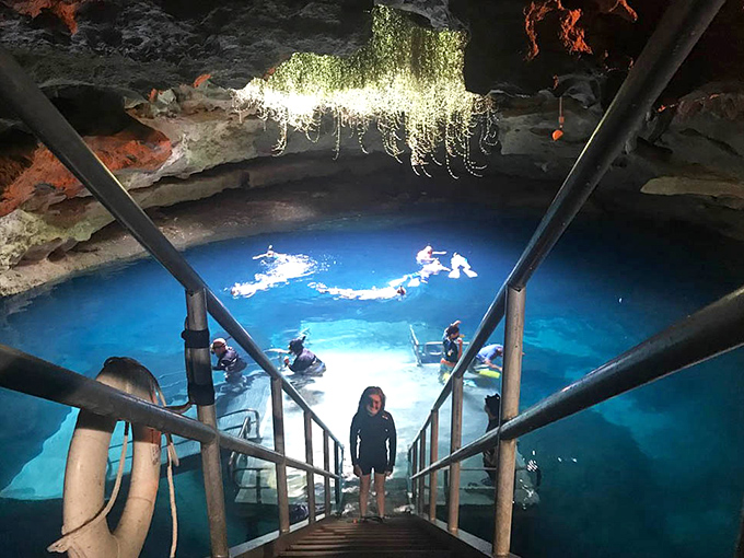 Explorers descend into the crystal-clear waters while hanging vines create a Jurassic Park vibe&mdash;minus the velociraptors, thankfully.