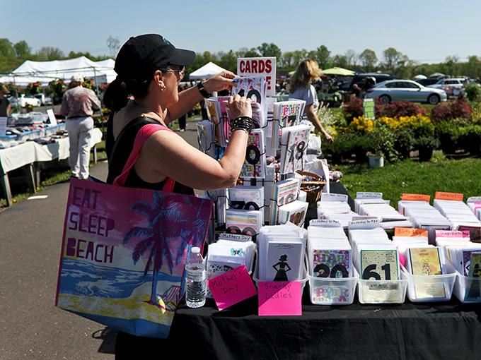 Serious shoppers know the greeting card section requires strategic browsing. This treasure hunter's reusable beach bag suggests she's no amateur at market navigation.