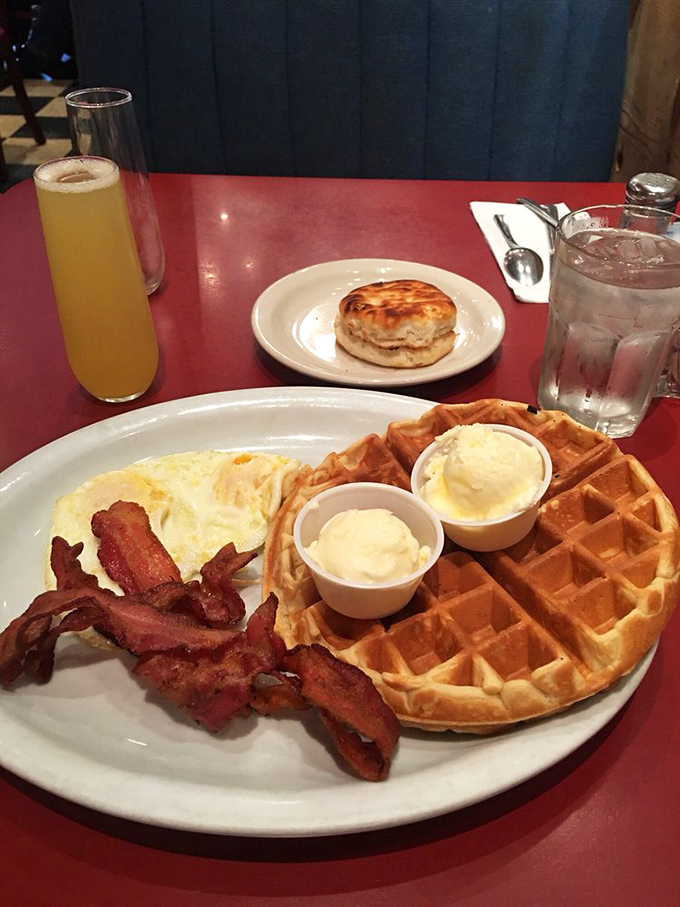 Golden waffle perfection meets crispy bacon in a breakfast symphony that makes morning people out of night owls. Those butter cups are little pools of joy!