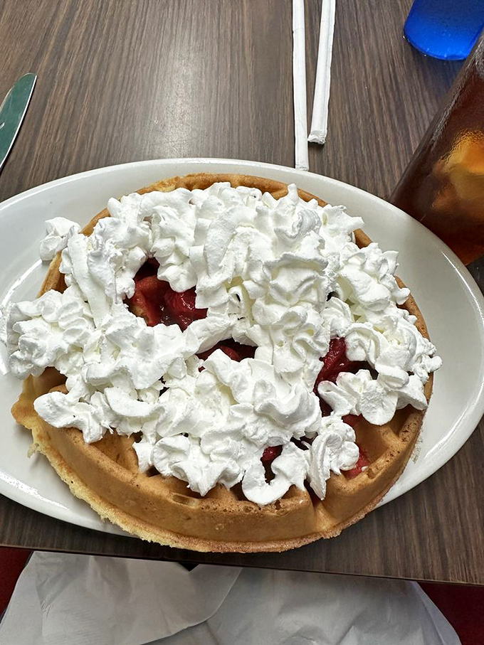 Waffle architecture at its finest! This cloud of whipped cream atop fresh strawberries isn't just breakfast&mdash;it's dessert with a morning permission slip.
