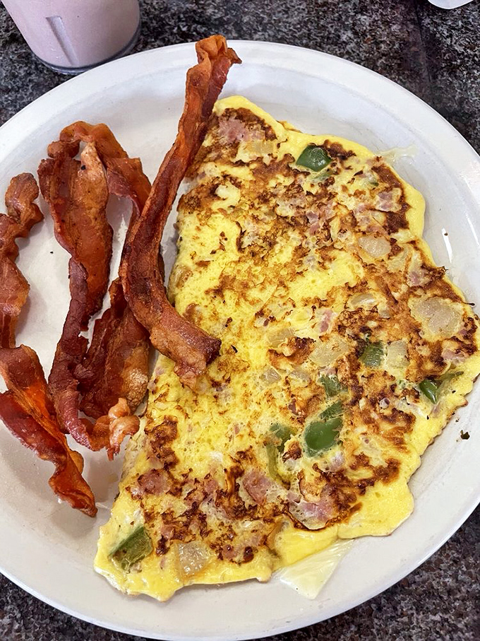 Behold the Western omelet in all its glory&mdash;a golden canvas of perfectly cooked eggs studded with ham, peppers, and onions. Bacon standing guard nearby.