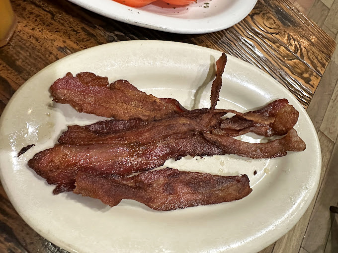 Behold the legendary Millionaire's Bacon &ndash; thick-cut, caramelized, and glistening with sweet-spicy goodness. This isn't breakfast meat; it's breakfast theater on a plate..
