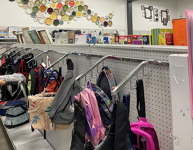 The bag section: where vintage purses and practical backpacks hang in suspended animation, waiting for their second act in someone's wardrobe story.