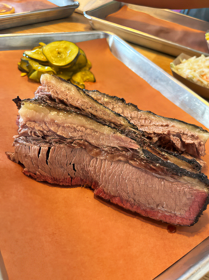 Behold the holy grail of barbecue: perfectly smoked brisket with that pink smoke ring. This isn't food; it's edible poetry with a bark.