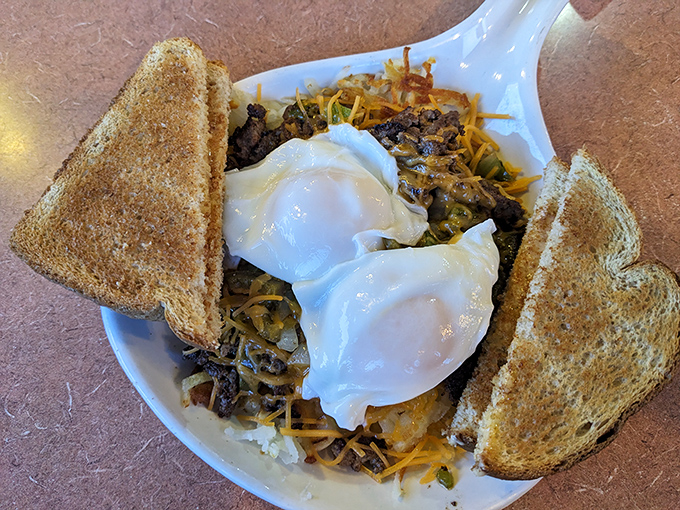 Breakfast nirvana: perfectly poached eggs atop a mountain of hash and cheese. Those crispy toast triangles are the ideal tools for mopping up every last bite.