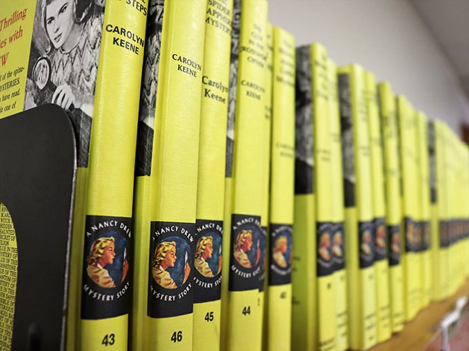 Nancy Drew mysteries lined up like soldiers in their iconic yellow jackets&mdash;literary nostalgia by the yard for anyone who grew up solving cases alongside America's favorite teen detective.