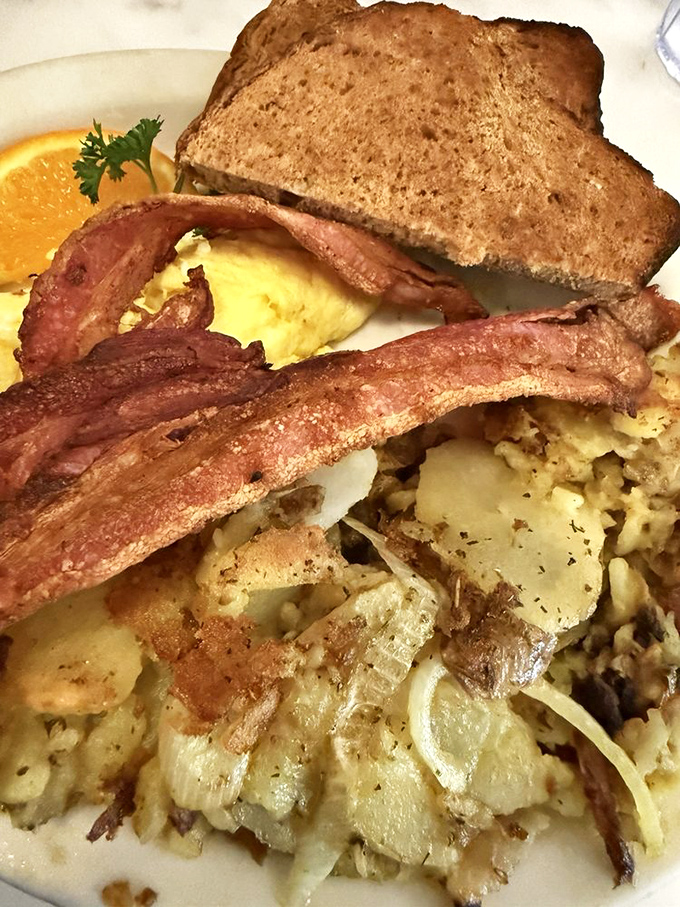 Breakfast architecture at its finest: perfectly crisped home fries, eggs with that ideal runny-to-set ratio, and toast that makes you question every other bread you've ever met. 