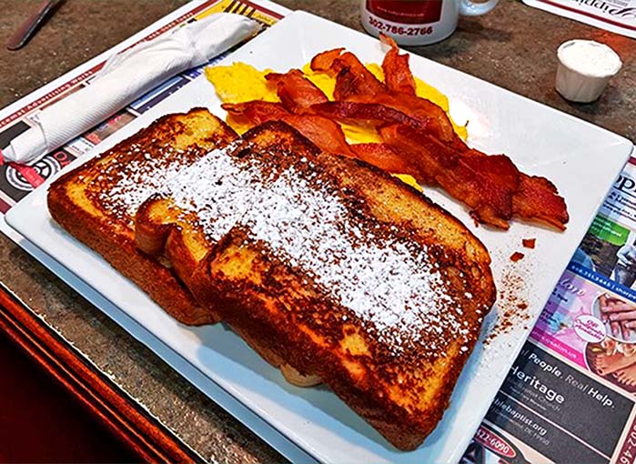 French toast that could make a Parisian weep with envy, dusted with enough powdered sugar to start a small snowstorm.
