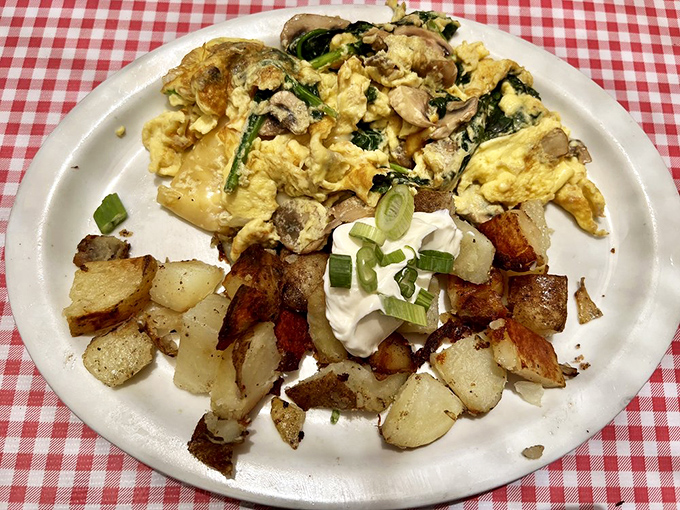 Scrambled eggs dancing with mushrooms and spinach alongside perfectly crisped potatoes &ndash; this plate doesn't just feed you, it hugs you from the inside.