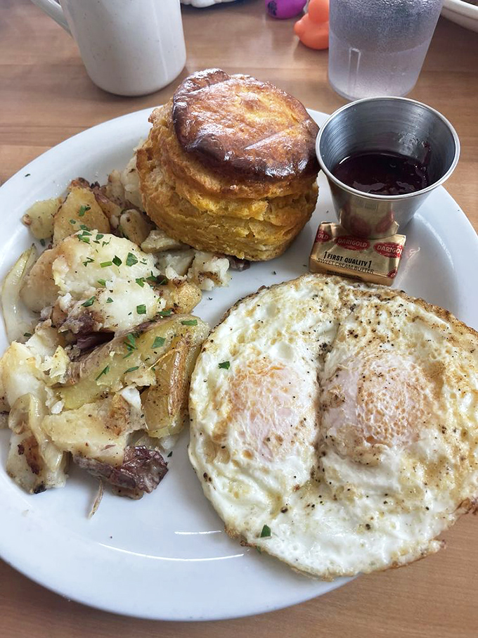 Breakfast nirvana on a plate: perfectly fried eggs, golden potatoes, and a biscuit that could make a Southerner weep with joy.