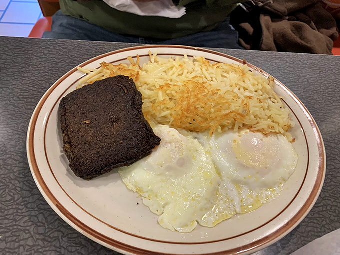Simplicity at its finest &ndash; perfectly cooked eggs, crispy hash browns, and what appears to be livermush, a Carolina breakfast tradition worth discovering.