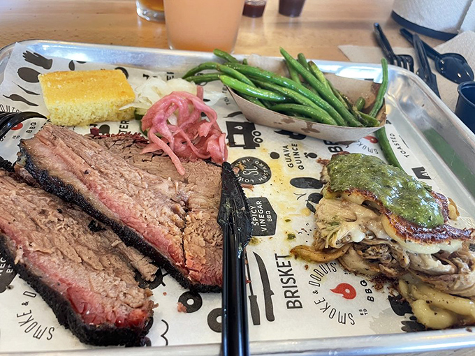 Brisket with that textbook pink smoke ring that makes barbecue enthusiasts weak in the knees. That cornbread square isn't just a side&mdash;it's essential flavor architecture.